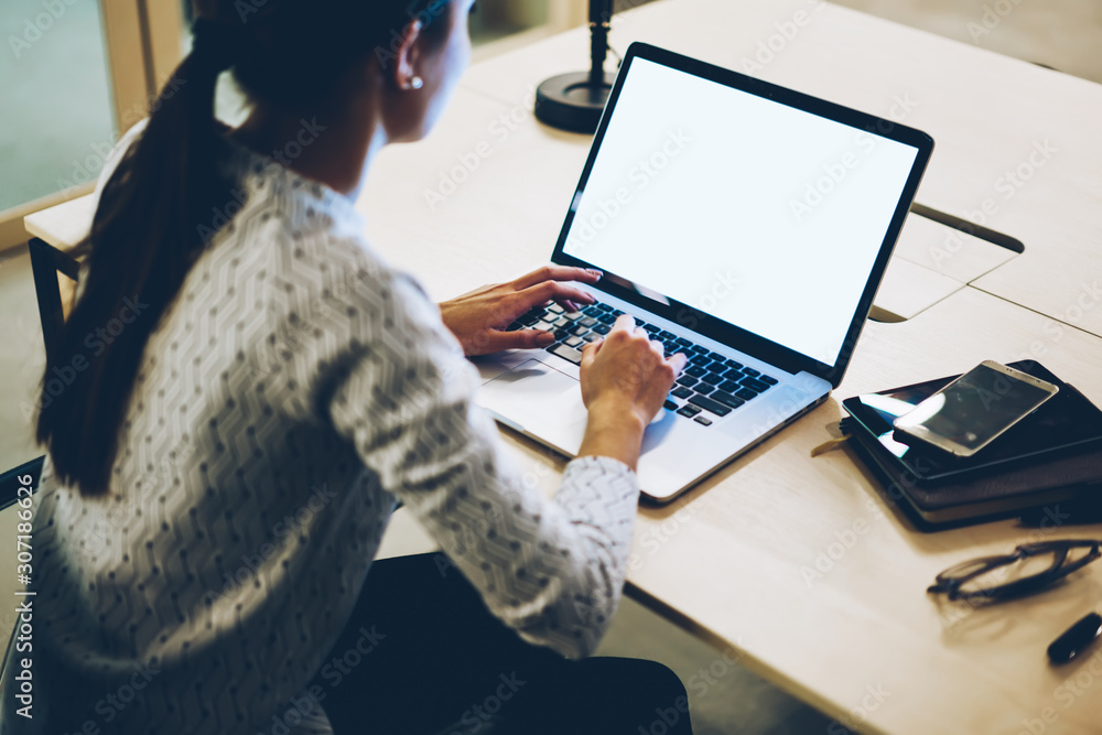 Cropped image of female employee typing on laptop computer with mock up ...