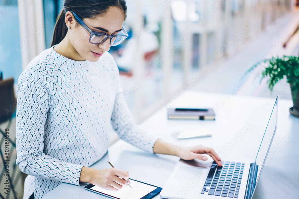 Foto de Experienced woman secretary signing documents via touchpad app ...
