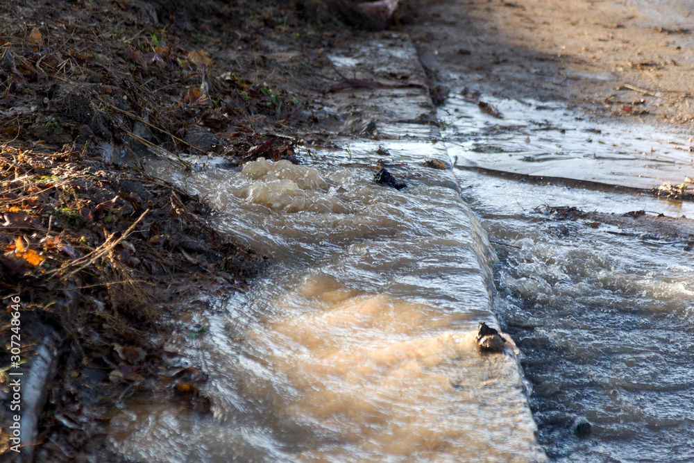 Emergency Sewerage. Water flows down the sidewalk from a ruptured ...