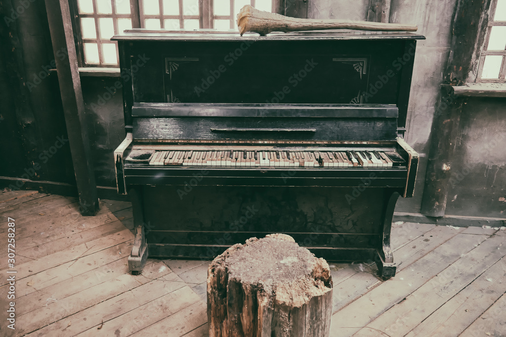 Broken piano in an old dirty building. Dusty wooden room with a ...