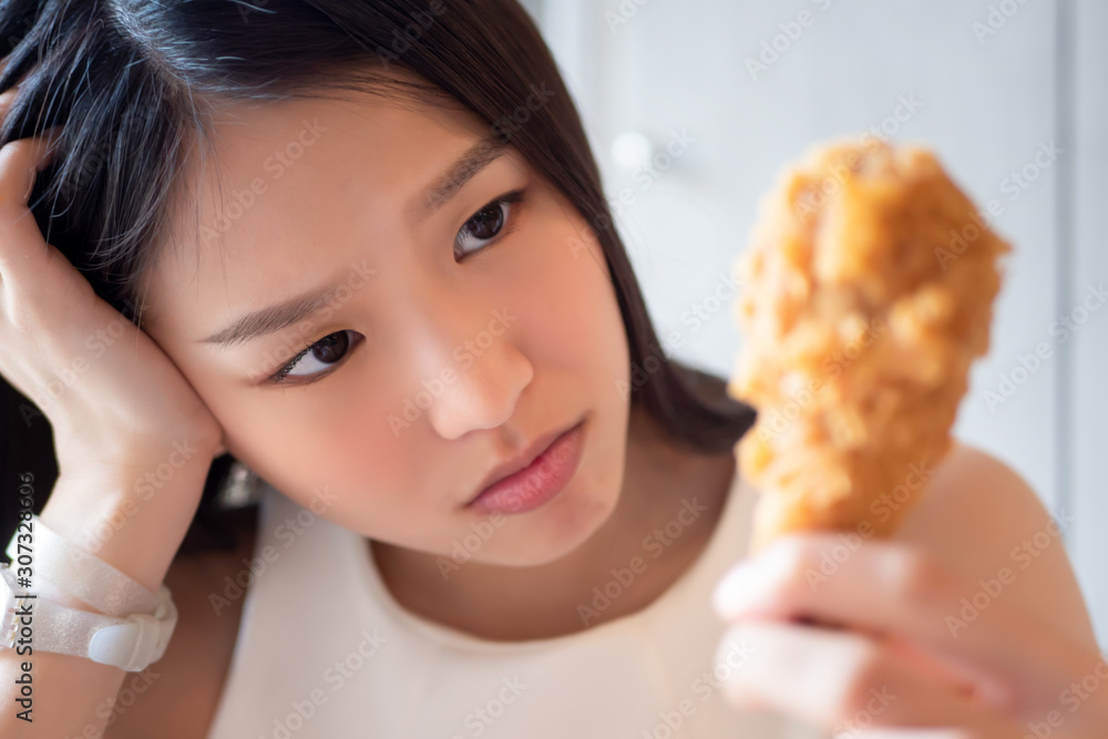 hungry worried woman looking and hesitating to eat fried chicken ...