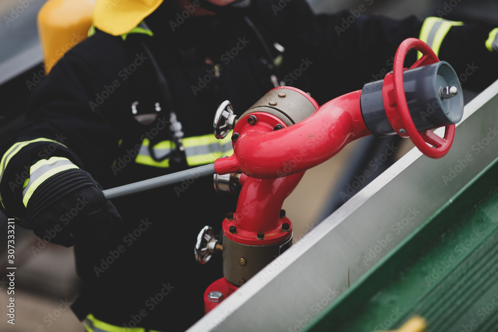 Details with the hands of a firefighter holding a fire suppression ...