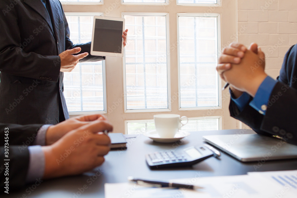 Business people holding tablets are presenting ideas and work at the ...