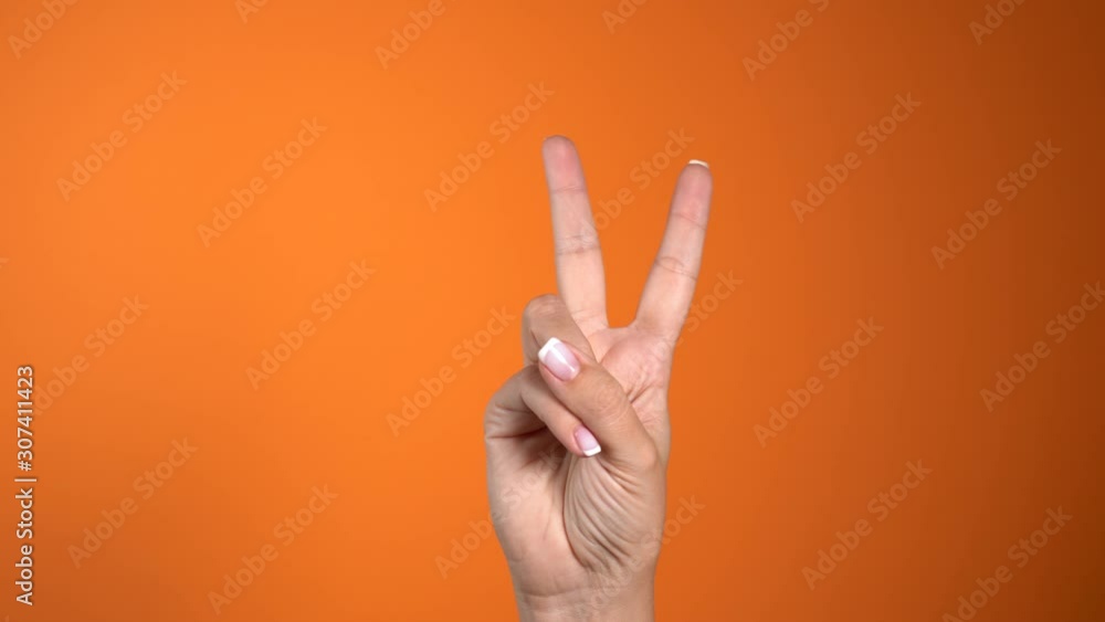 Woman raising two fingers up and showing peace or victory symbol or ...