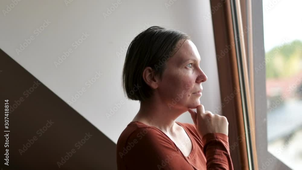 Sad woman looking out of the window in loft apartment Stock Video ...