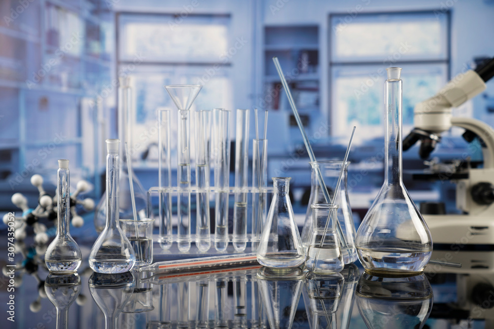 Science laboratory. Beakers, test-tubes and microscope on glass table ...