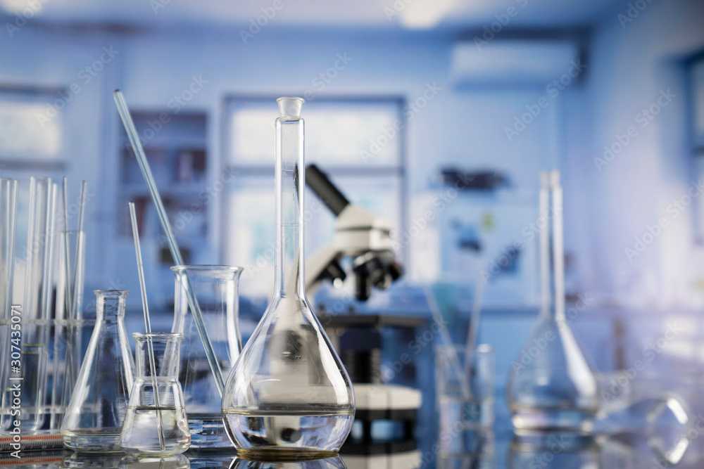 Science laboratory. Beakers, test-tubes and microscope on glass table ...