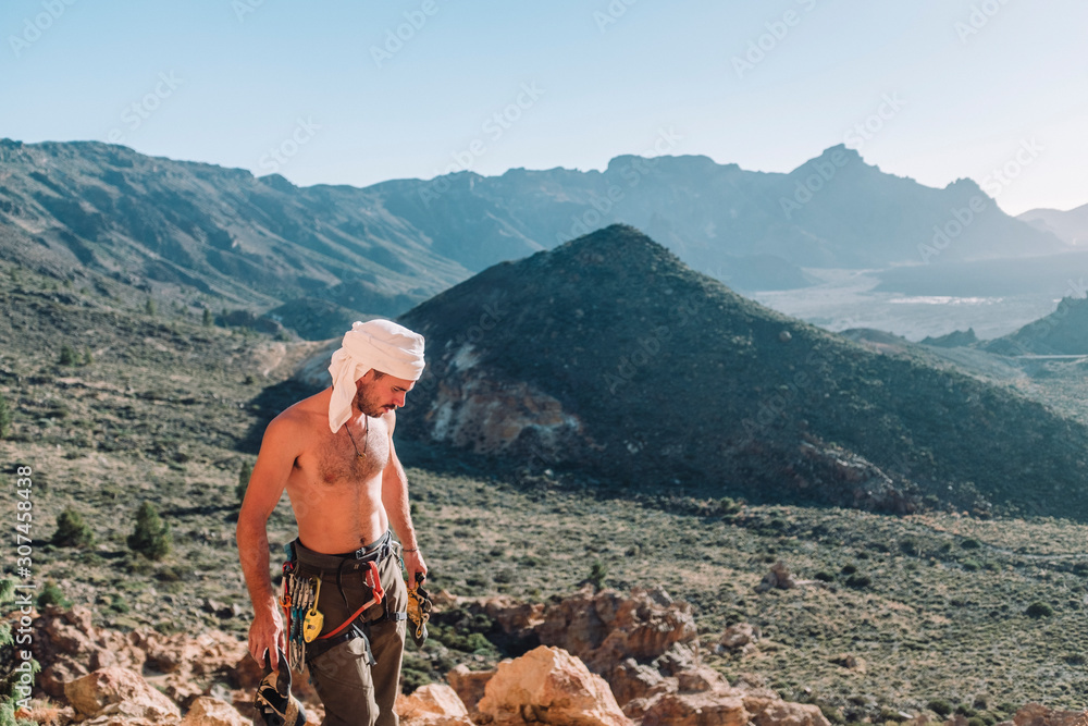 Upper body of shirtless male climber standing in mountain Stock Photo ...