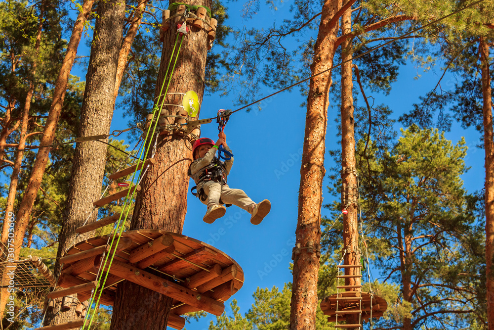 enjoying activity in climbing adventure park. summer day. Rope park ...