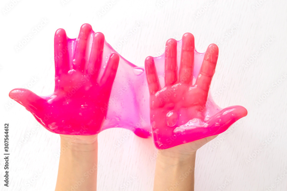 Modern toy called slime. Child playing transparent pink slime. Hands ...
