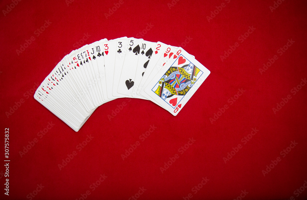Deck of playing cards on red color velvet background. Top view with ...