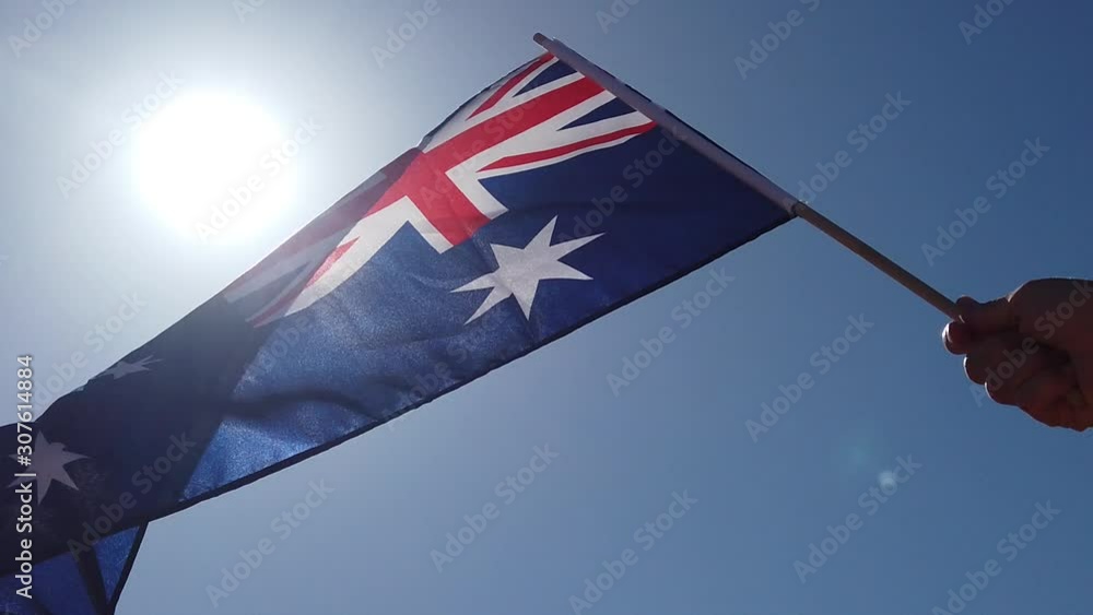 SLOW MOTION close up of waving Australian flag against the sun in the ...