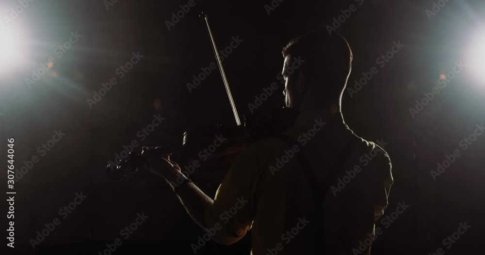 Popular musician playing solo on his his instrument violin on smoked ...