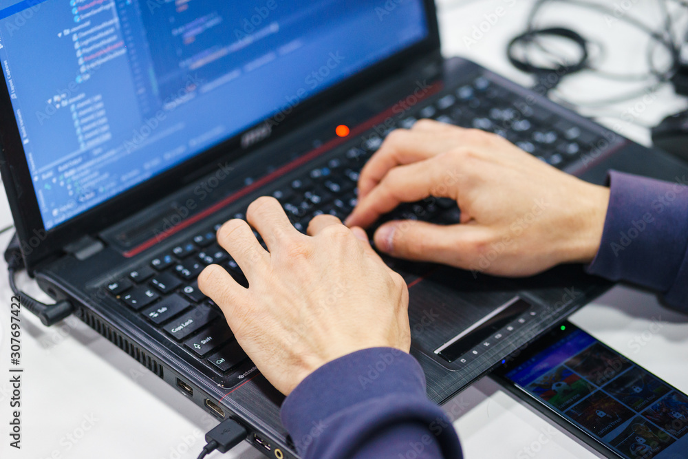 programmer coder working on his laptop. Software development. Programmer coding web application ...
