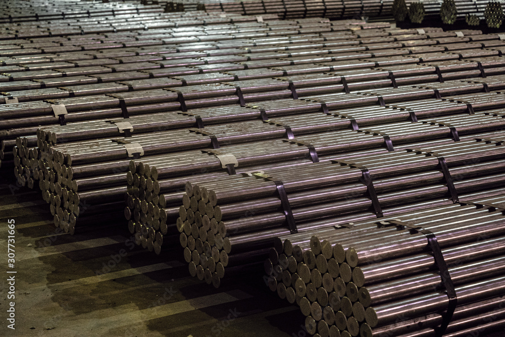Warehouse of metal products. Stacked round steel section rolling ...