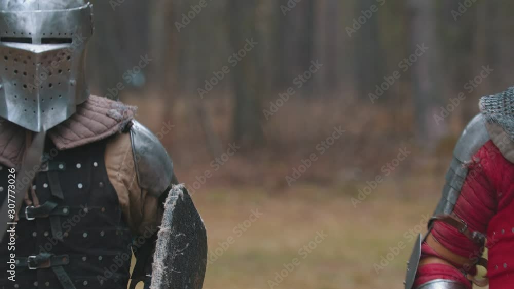 Two men knightes running in the row in the forest in full armour ...