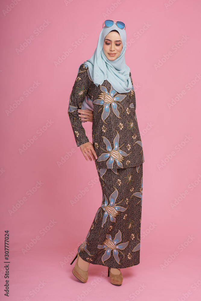 Beautiful female model wearing batik design "baju kurung" with hijab, a ...