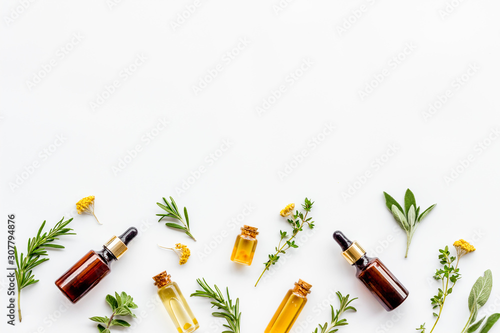 Essential oils and fresh herbs on white background top view pattern ...