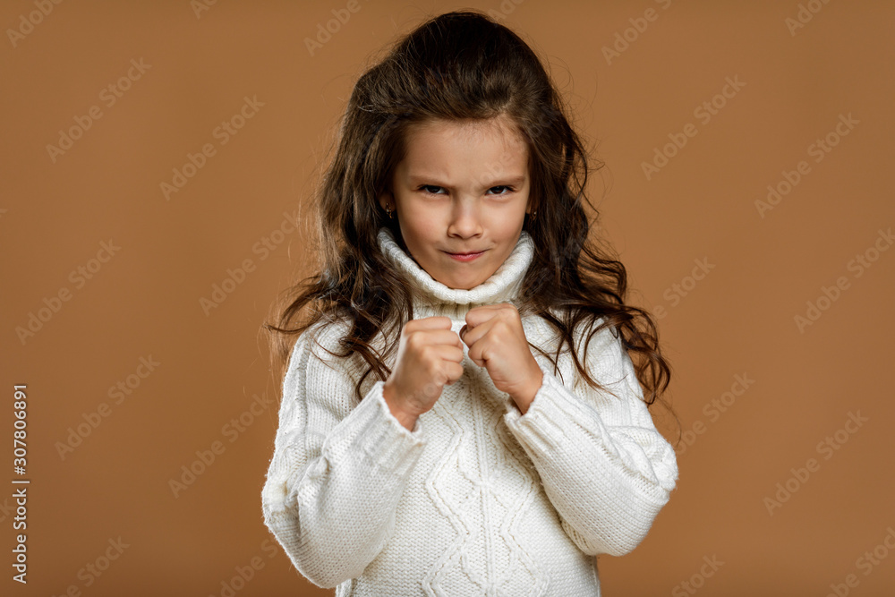 angry screaming little child girl in white sweater mad raising fist ...