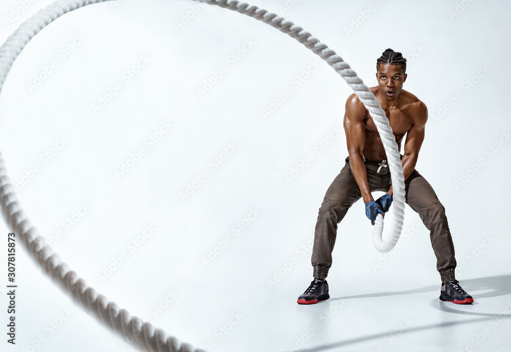 Man doing exercises with battle rope. Photo of muscular model with ...