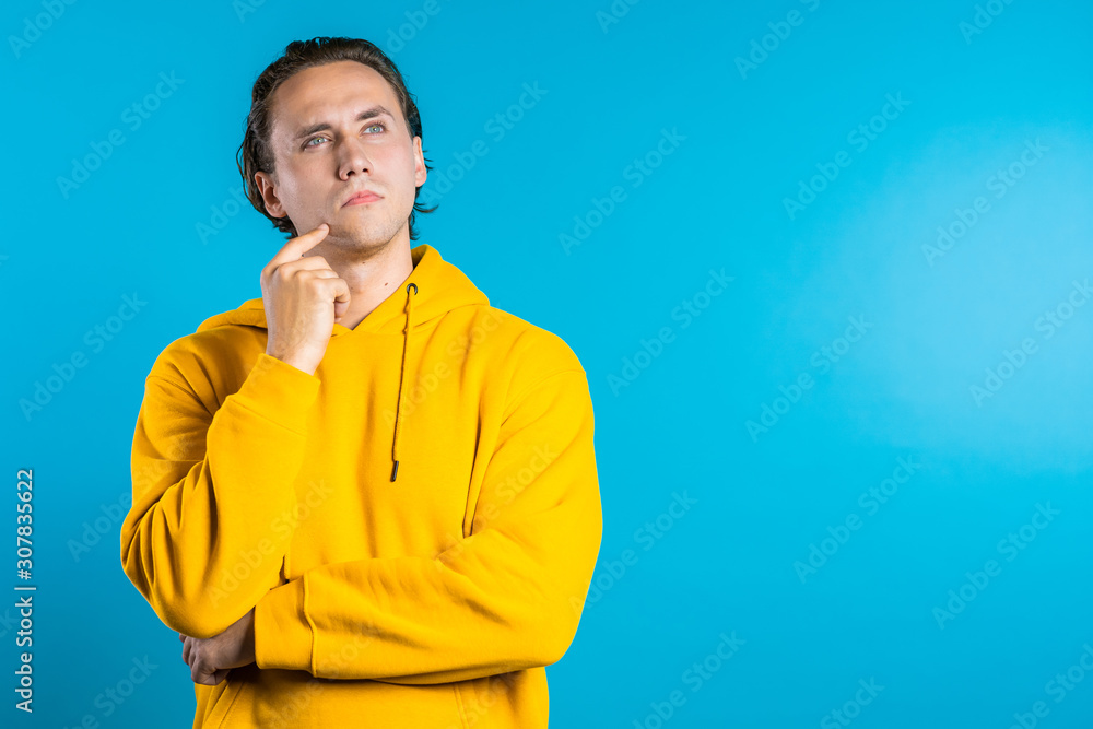 Copy space.Thinking man looking up and around on blue background ...