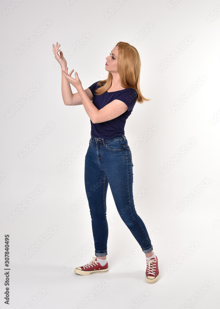 Full length portrait of a pretty blonde girl wearing casual blue shirt ...
