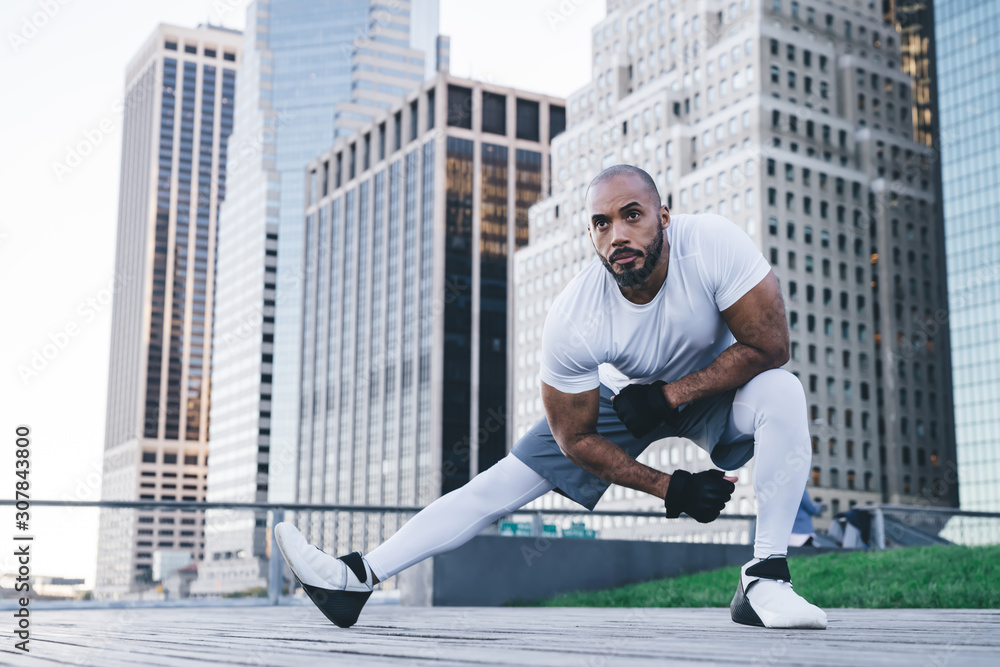 Athletic black man stretching legs before workout Stock Photo | Adobe Stock
