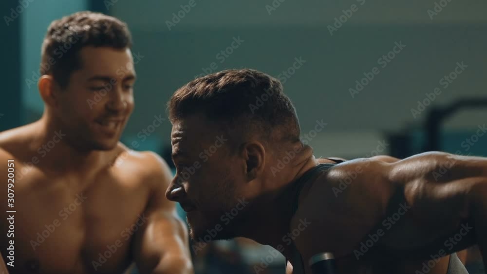 Two bodybuilders strong athletic men pumping up muscles workout fitness ...