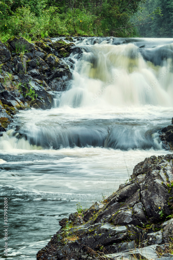Powerful stream of water in a waterfall in a beautiful natural park ...