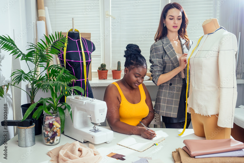 beautiful woman seamstress with long hair and afro customer. tailor ...