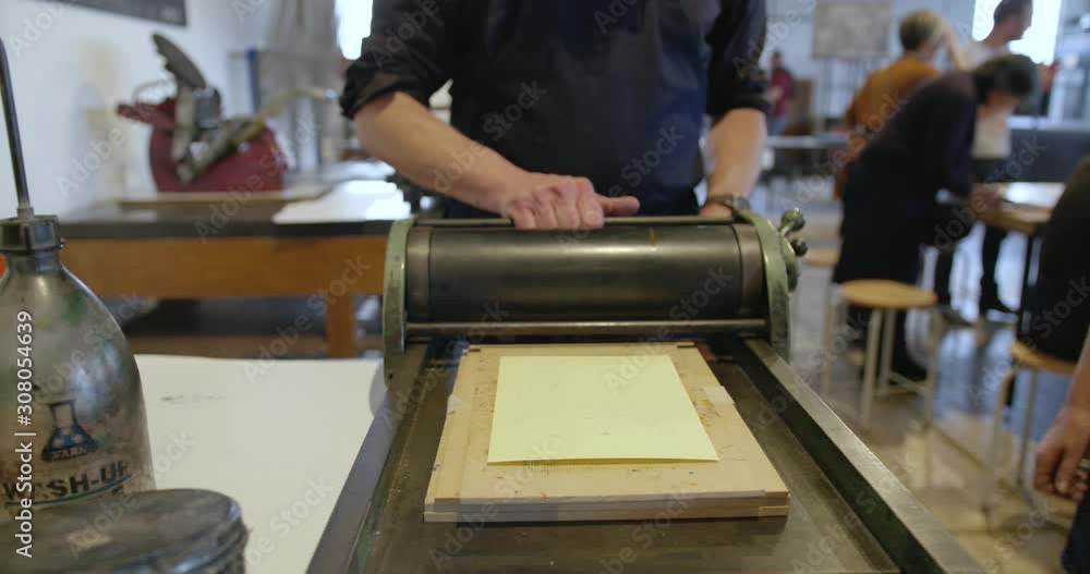 Man hand pulling a lino printing press. Printing a drawing on linoleum ...