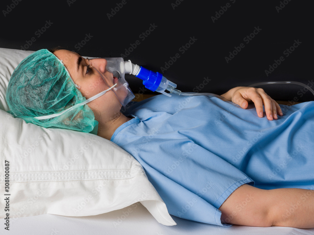 Teenage girl lying in a hospital bed, with oxygen mask Stock Photo ...