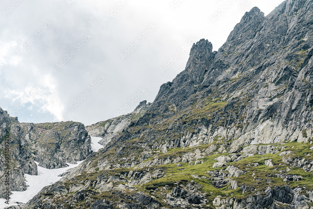 Detail of a mountain rock face, background or wallpaper picture of big wall rock climb, clouds ...