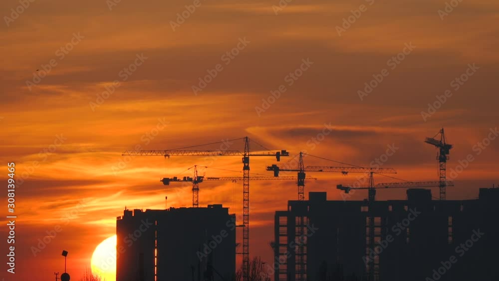 Construction of a high-rise building on a sunset background ...