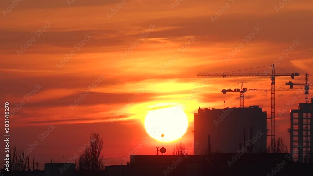 Construction of a high-rise building on a sunset background ...