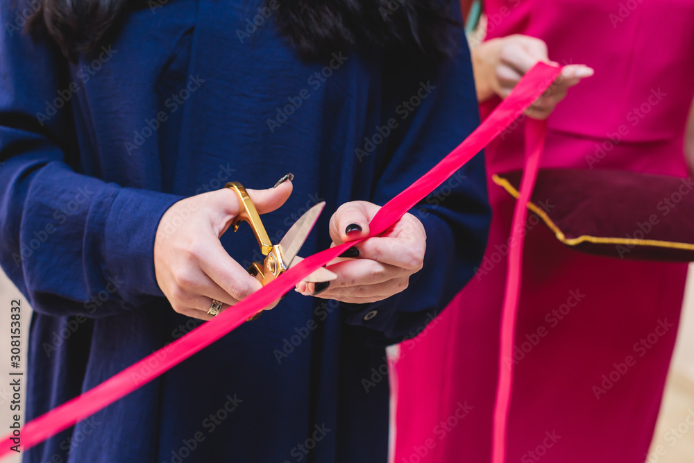 Process of cutting the red ribbon during the grand opening of the new ...