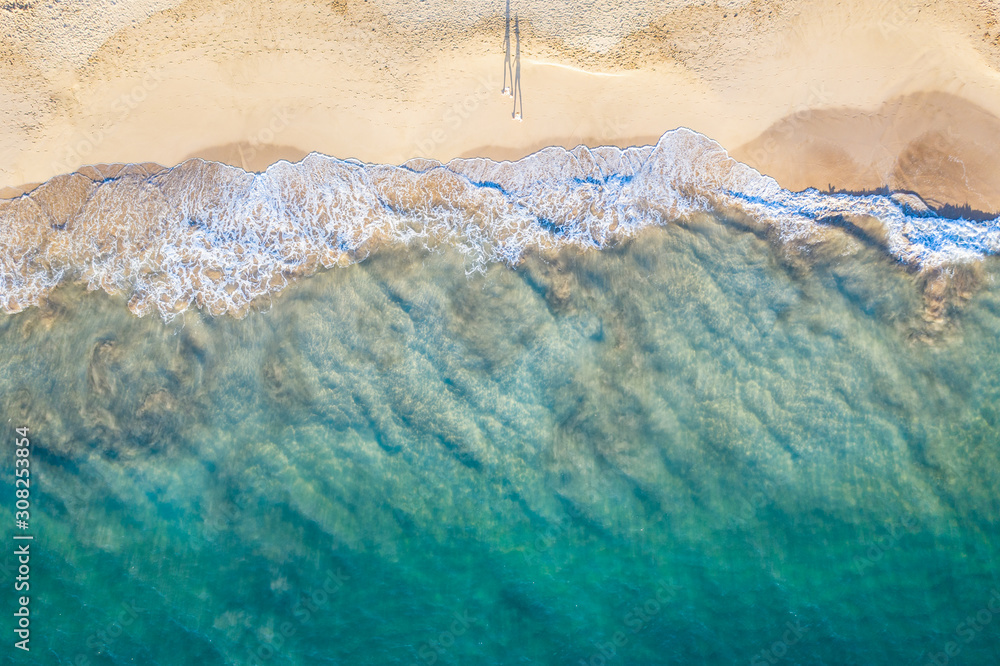 Ocean beach aerial top down view with blue water, waves with foam and ...