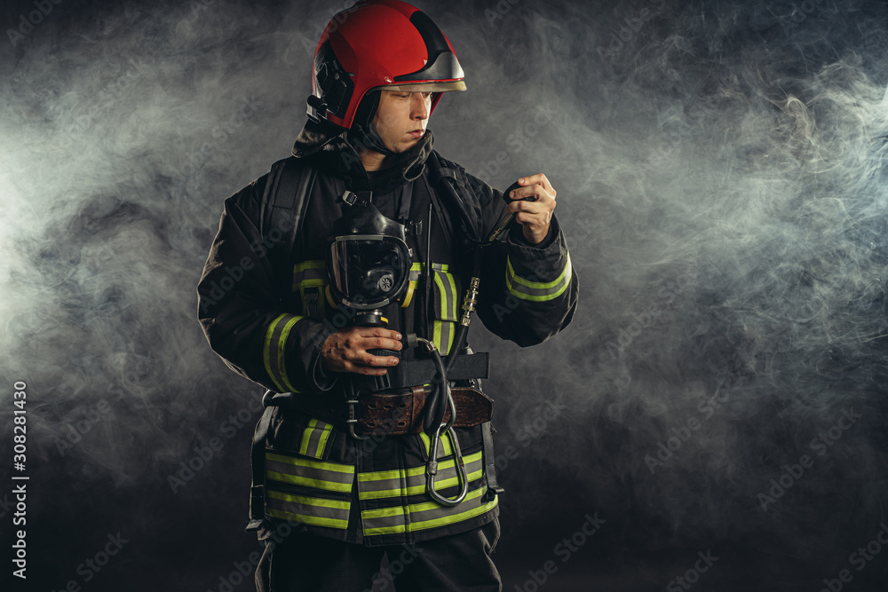 brave firefighter extinguishing fire in smoke, using special equipment ...