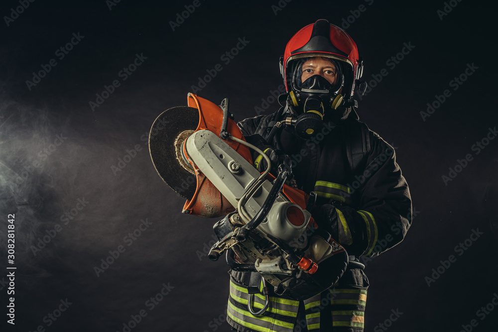 young extinguisher holding chainsaw stand isolated over smoky ...