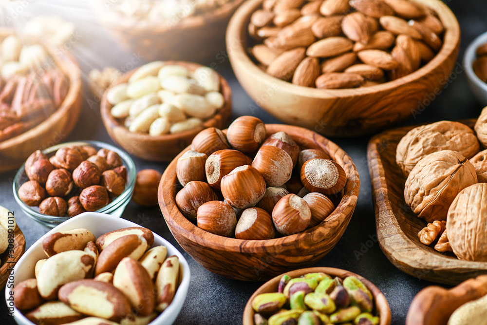 A variety of nuts in wooden bowls from top view. Walnuts, cashew ...