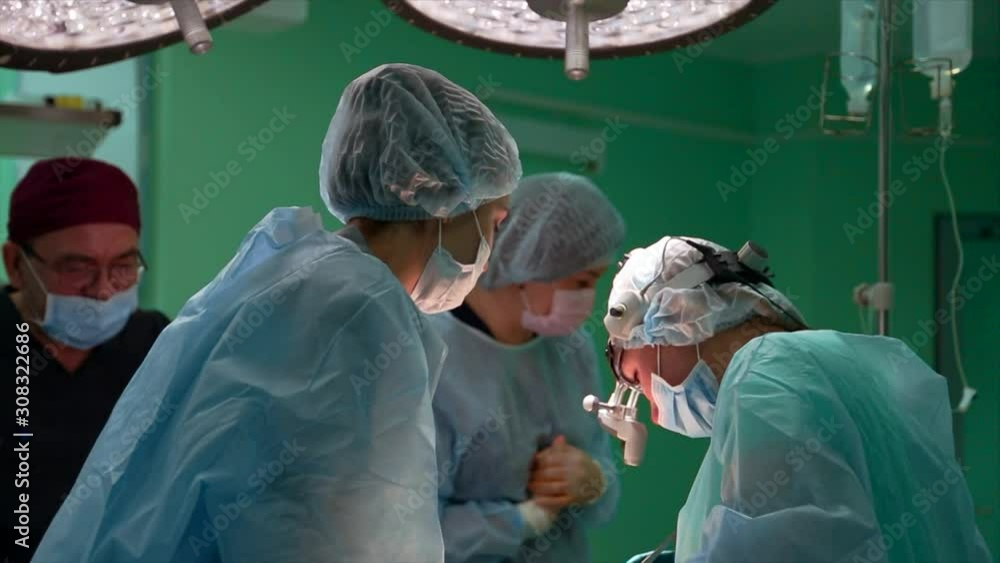The surgeon and surgical team perform cosmetic surgery on the Breasts ...