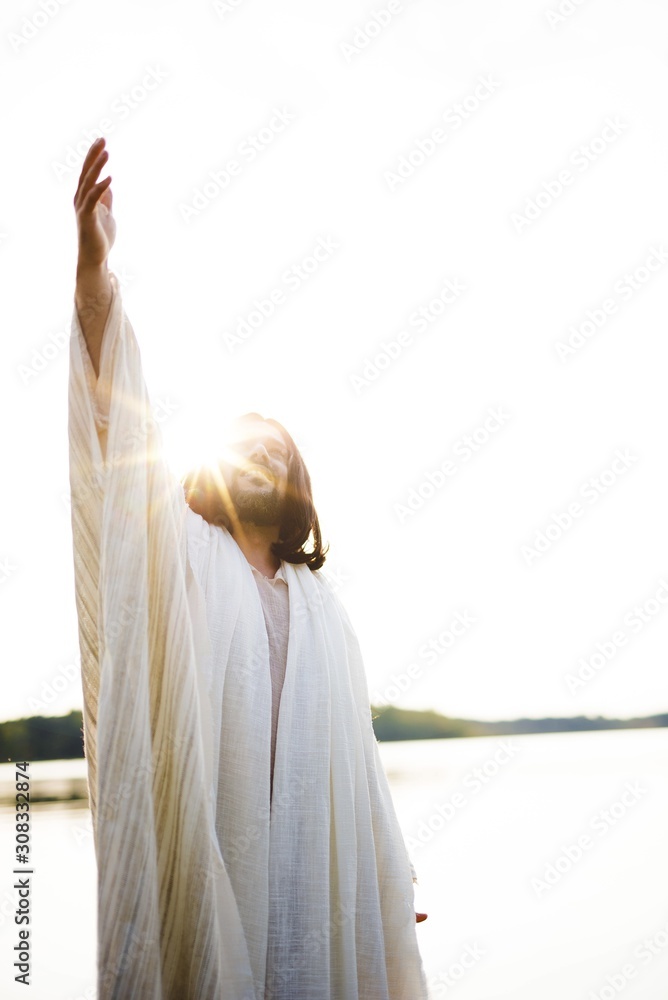 Vertical shot of Jesus Christ with his hand up towards the sky while ...