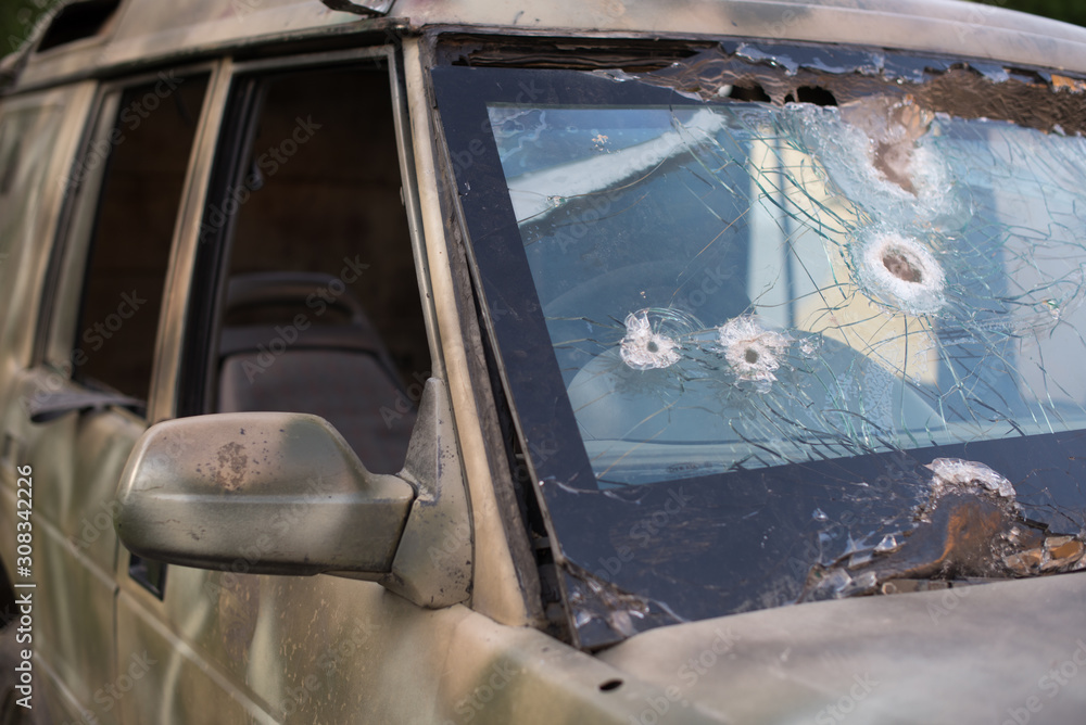 Bullet hole on a car windshield. Car window after a raid has a bullet ...