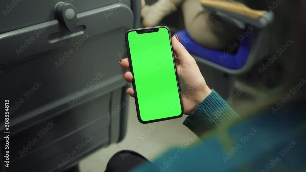 Young woman hold use green screen phone sitting in bus touch telephone ...