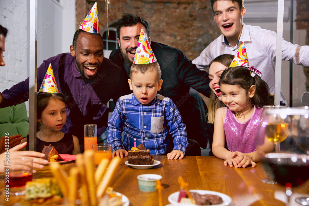 Portrait of happy multiethnic family celebrating a birthday at home ...