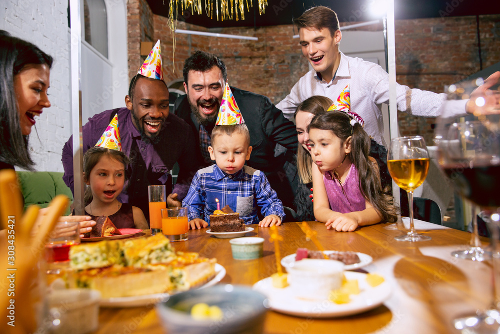 Portrait of happy multiethnic family celebrating a birthday at home ...