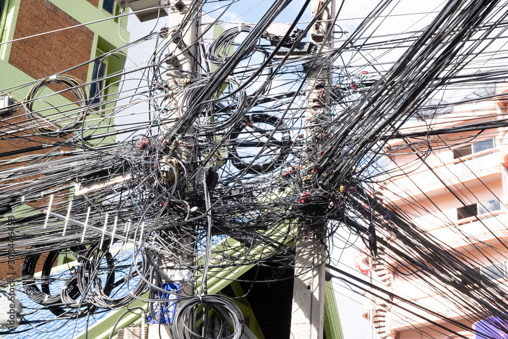 Foto de Messy wires attached to the electric mast. The chaos of cables ...