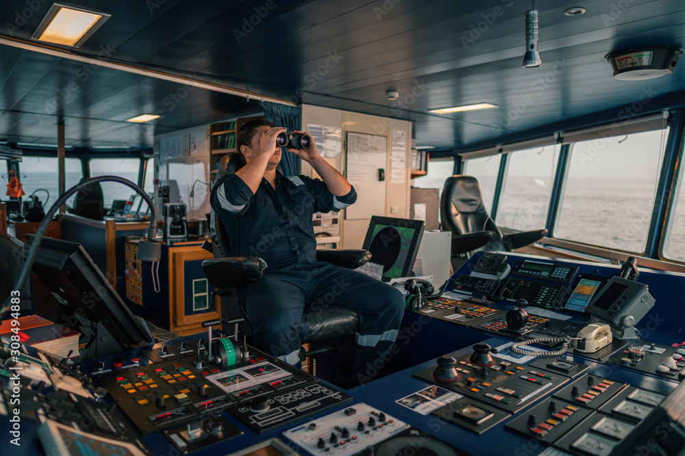 Navigational officer lookout on navigation watch looking through ...