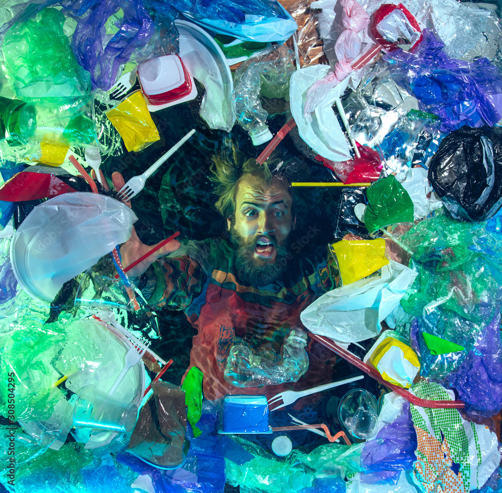 Man drowning in water under plastic recipients pile, garbage. Used ...