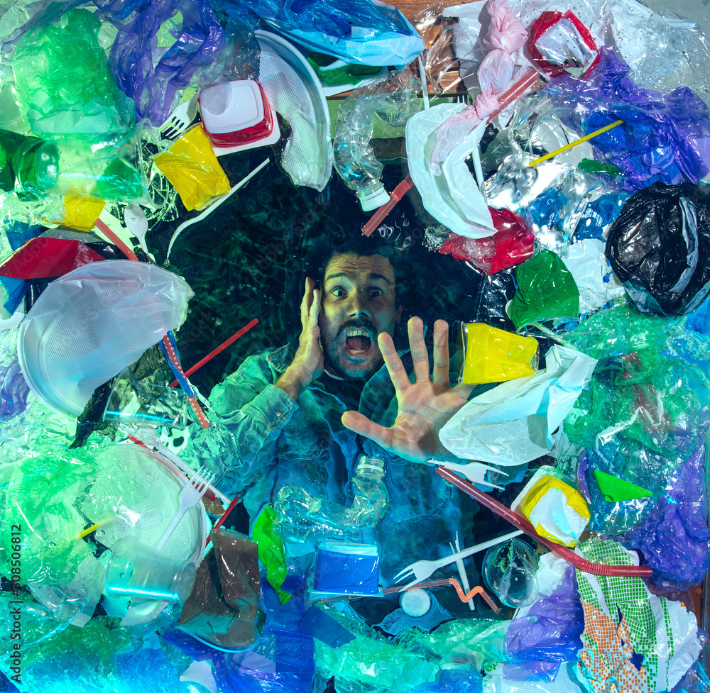 Man drowning in water under plastic recipients pile, garbage. Used ...